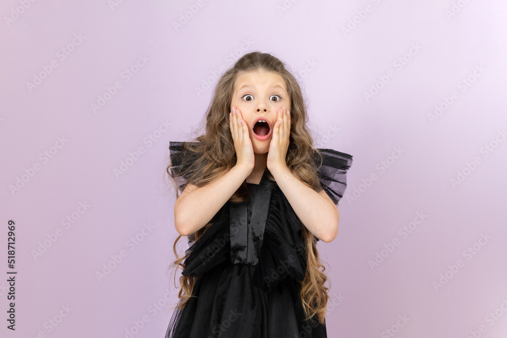 The shocked child opened his mouth wide and put his hands on his cheeks ...