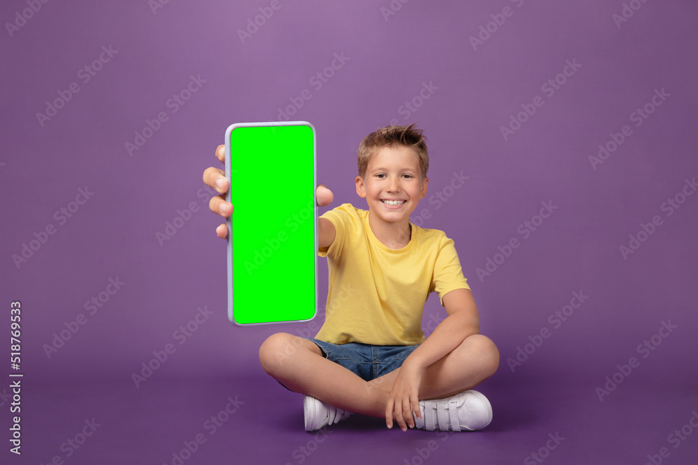 Happy smiling cute kid boy showing cell phone with green screen chroma ...