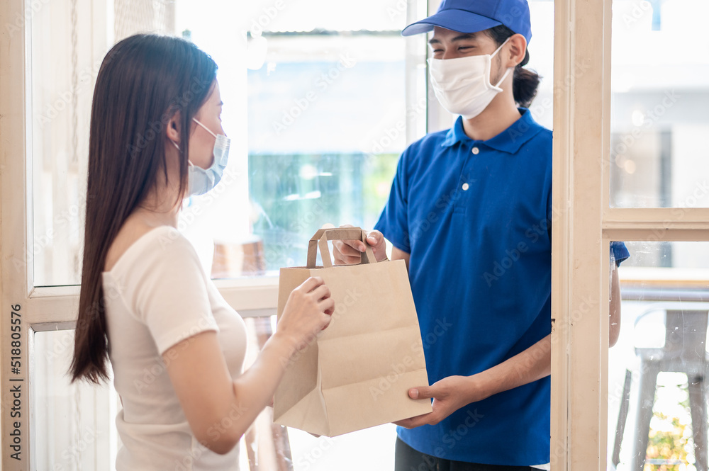 Young Asian woman wearing face mask receiving food and drink package ...