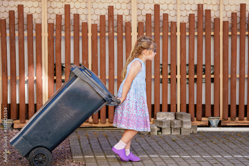 Little preschool girl with glasses taking garbage can. child learning ...