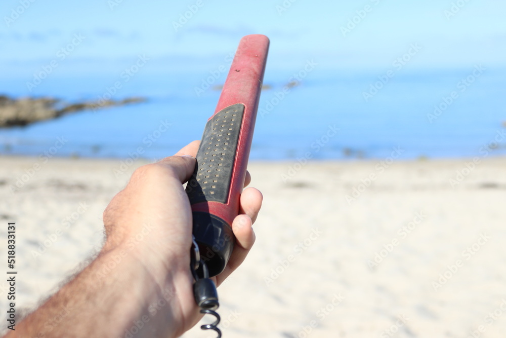 pinpointer in a hand at the beach on the sand Stock Photo | Adobe Stock