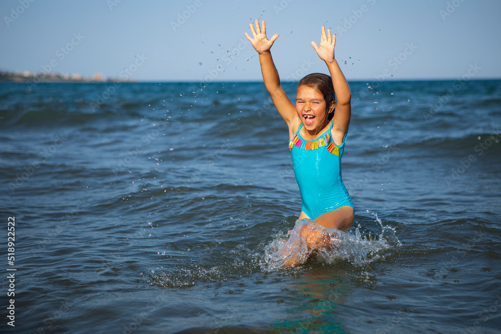 happy child jumping on the waves in the sea while relaxing on vacation ...