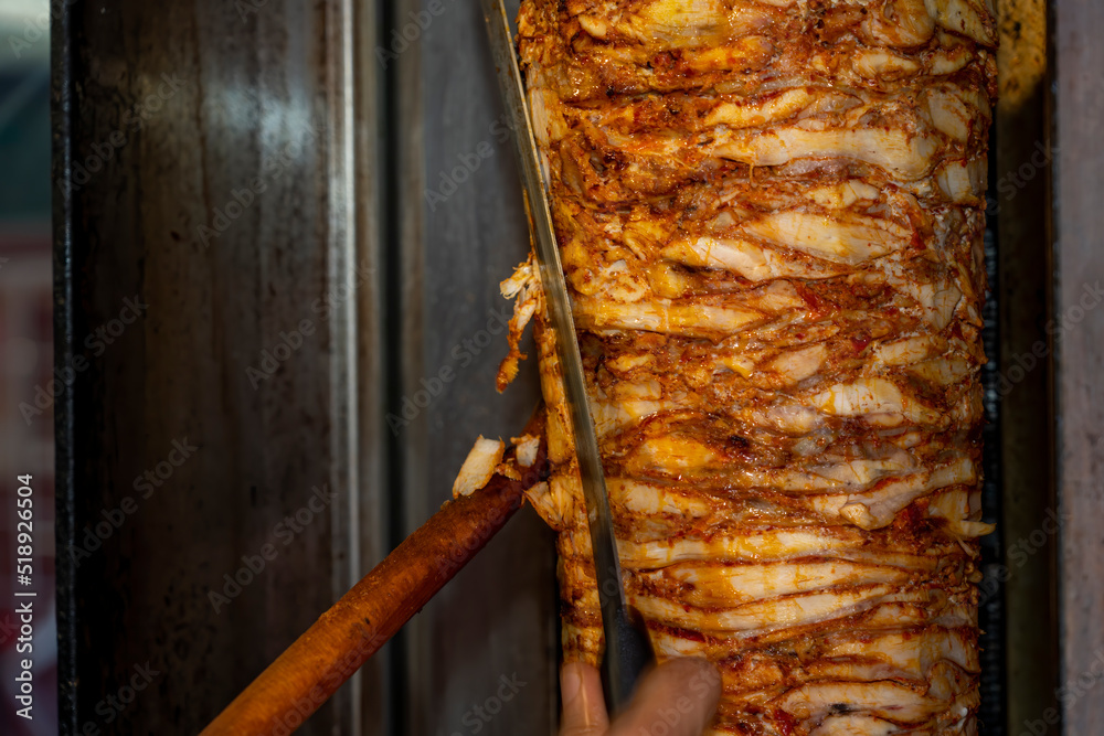 Doner kebab popular fast food cooked on a vertical rotisserie. Stock ...
