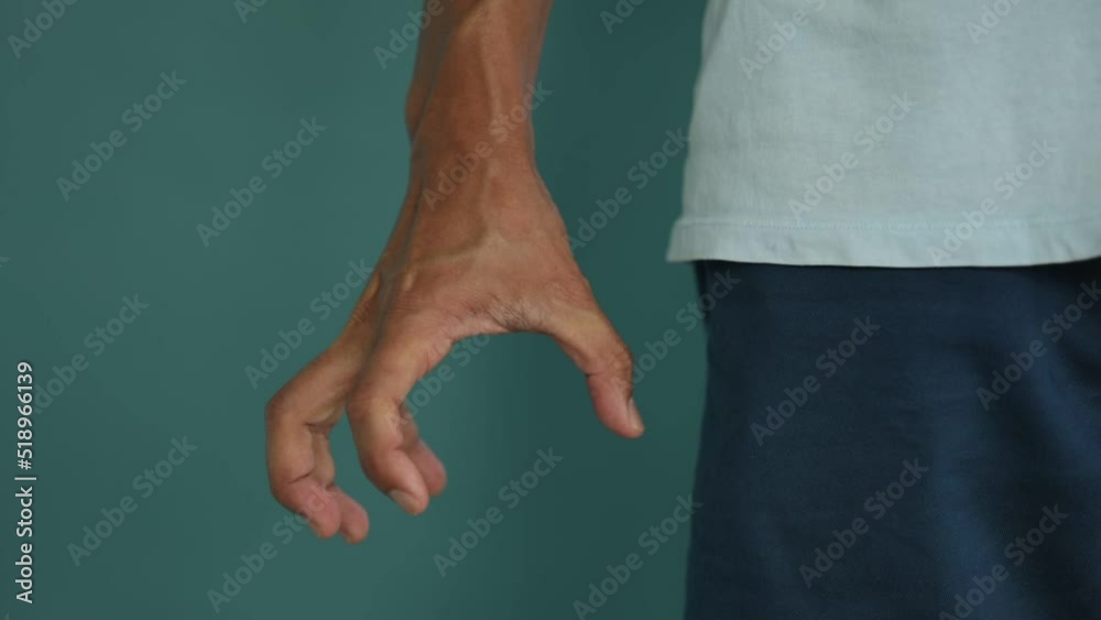 The right hand of an Asian Thai man spread out and tensed his hand ...