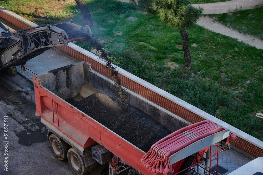 Cold milling machine removing the old asphalt and loading it into a ...