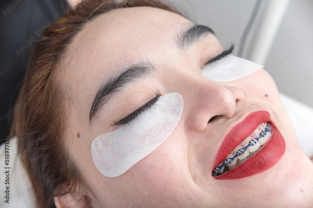 An asian woman with an eye pad placed just below her lower eyelashes ...