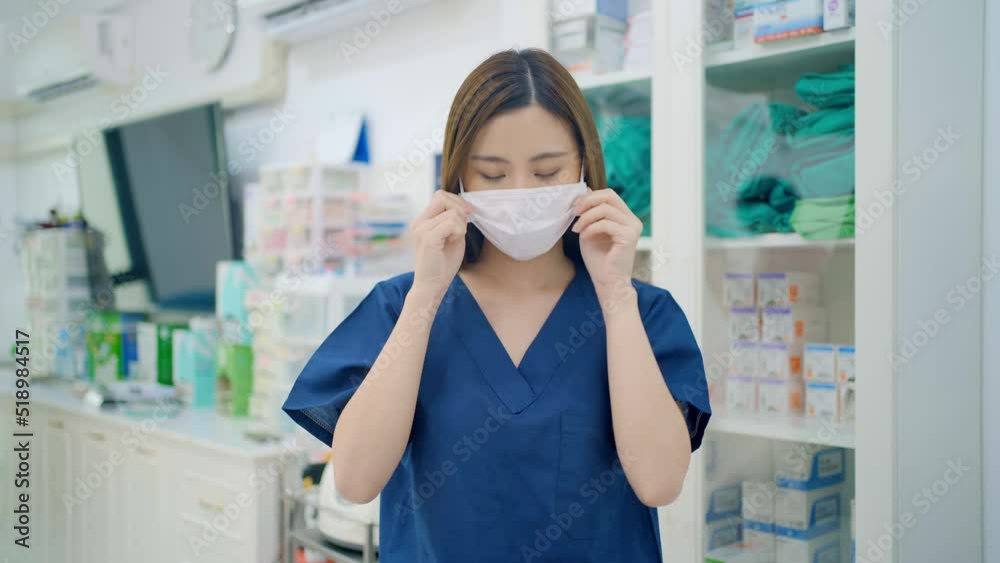 Young beautiful long-haired Asian female nurse or doctor in a blue ...