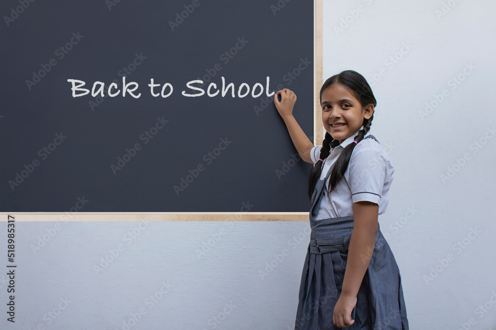 Indian school girl writing on black board Stock Photo | Adobe Stock