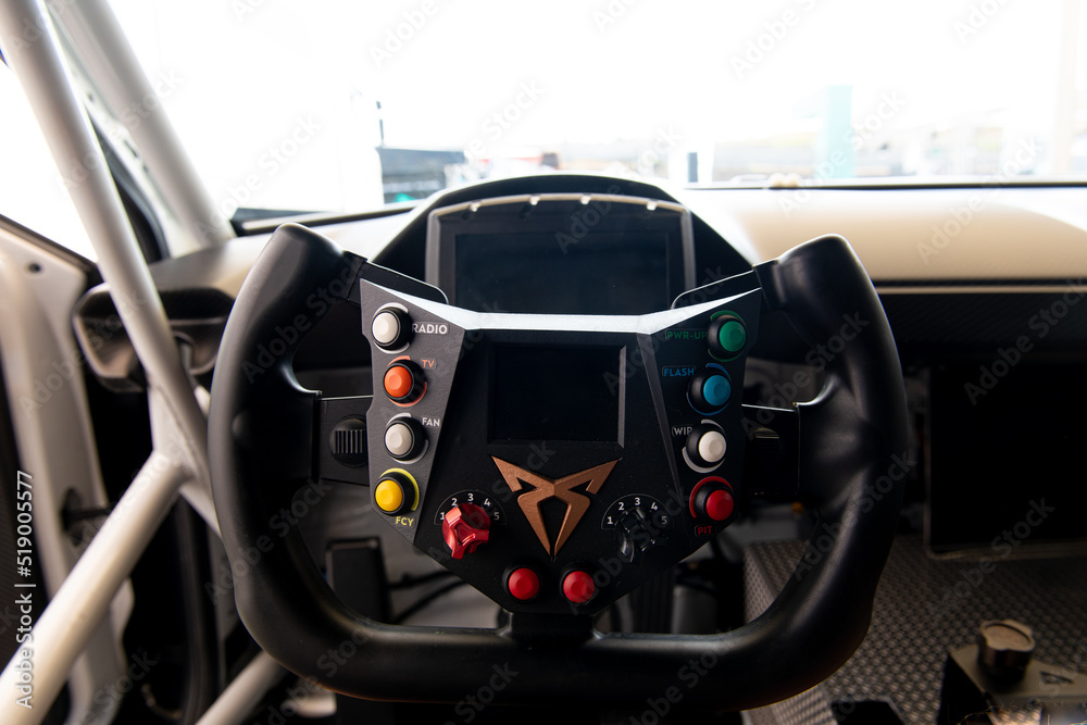 Race car driver point of view inside cockpit, steering wheel with knobs ...