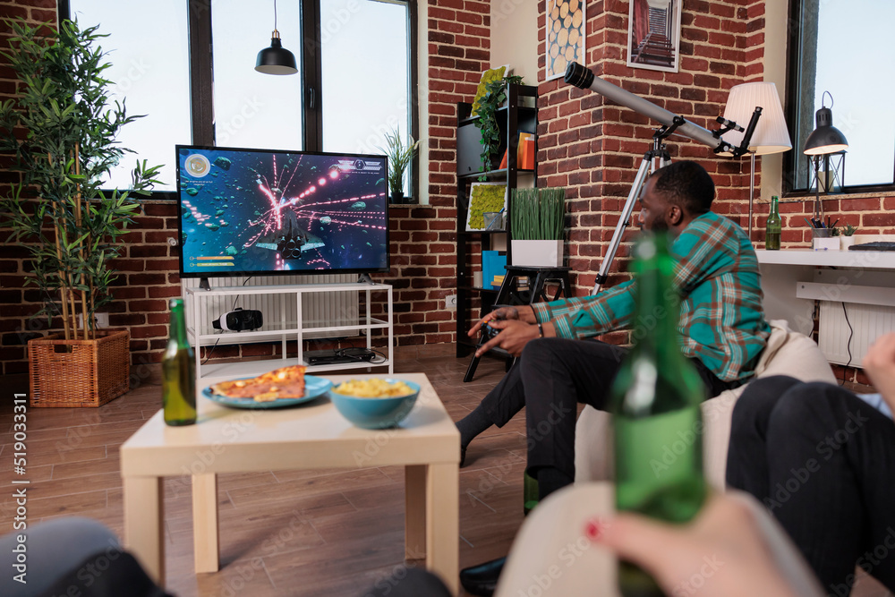 Modern male person playing video games on tv console, using strategy to ...