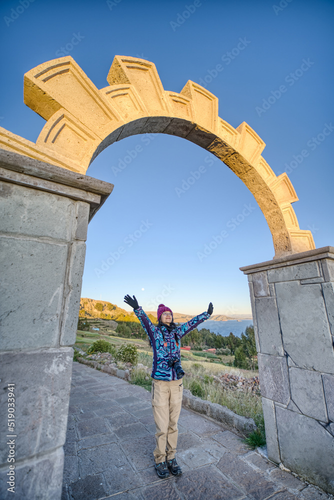 woman in triumphal pose, arriving at the sun arch, illuminated by the ...