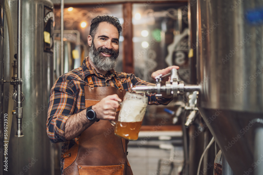 Brewery master tasting beer in production facility. Small family ...