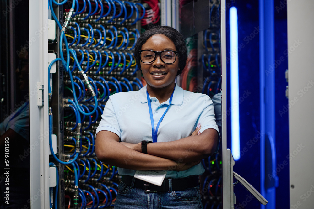Portrait of African female engineer smiling at camera standing with her ...