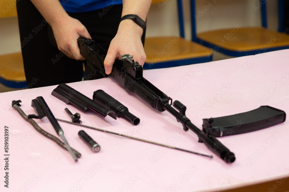 Assembling and disassembling a Kalashnikov assault rifle on a table ...