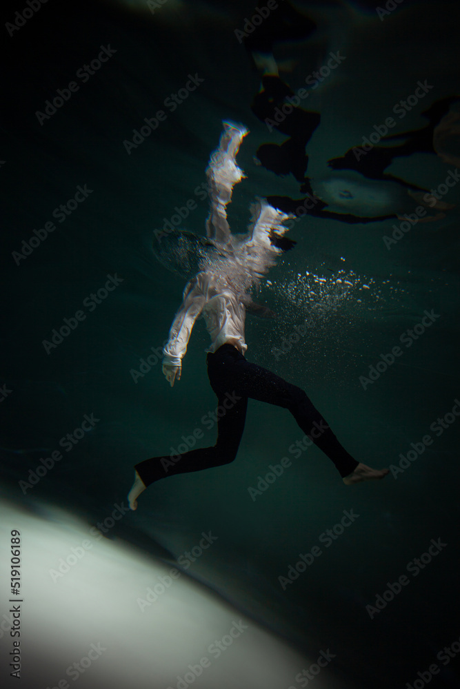 Beautiful underwater shooting, guy in white shirt and pants has fallen ...
