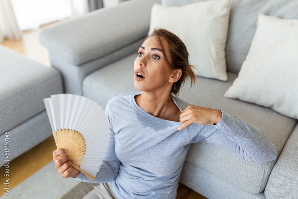 Poster Stressed annoyed woman using waving fan suffer from overheating ...