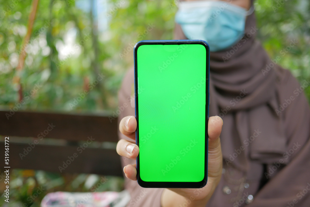 young women with face mask showing using smart phone with green screen ...