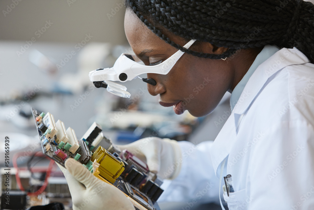 Side view portrait of black female scientist wearing magnifying glasses ...