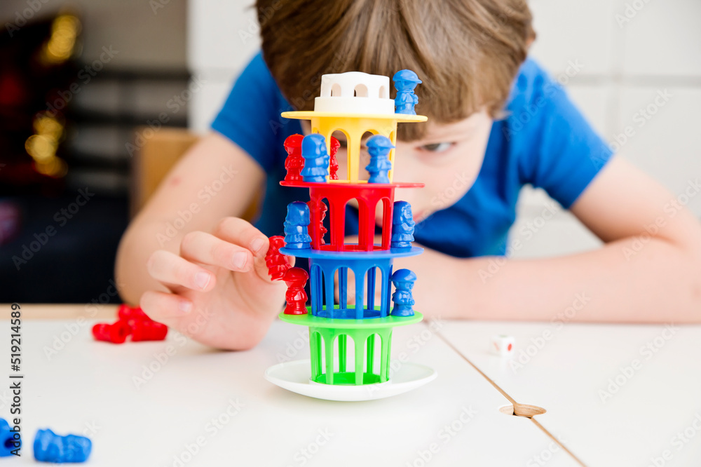 Balancing table game for kids. Tower with colorful figures. Boy plays ...