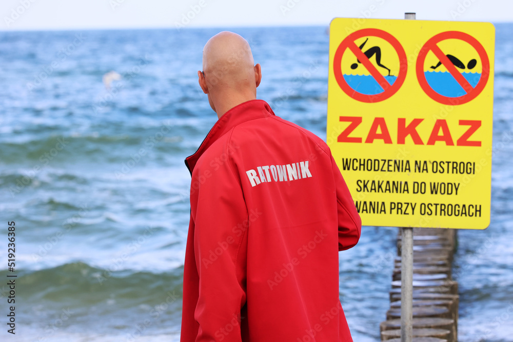 Ratownik na plaży podczas patrolowania brzegu wody nad morzem latem ...