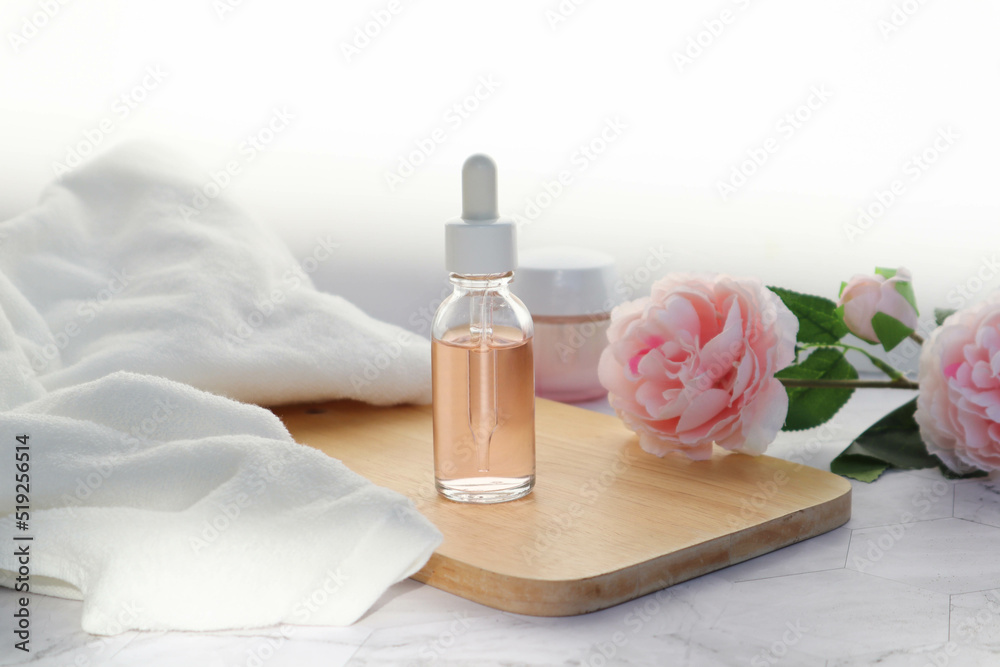 Skin care pink serum in clear glass bottle with pink rose. Cosmetic ...
