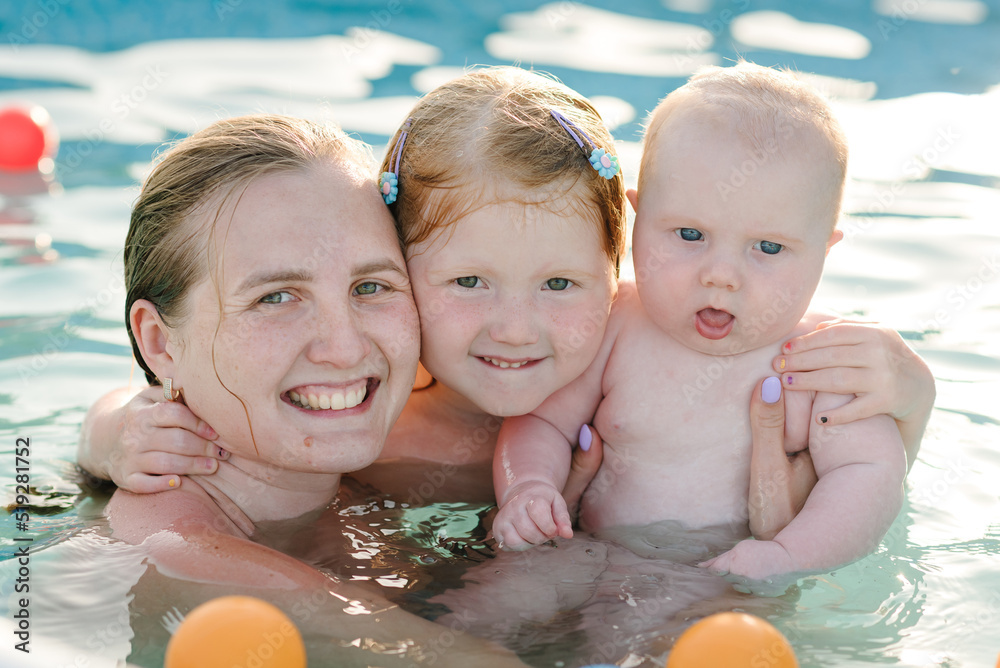 Mother and kids having fun in the swimming pool. Summer leisure and ...