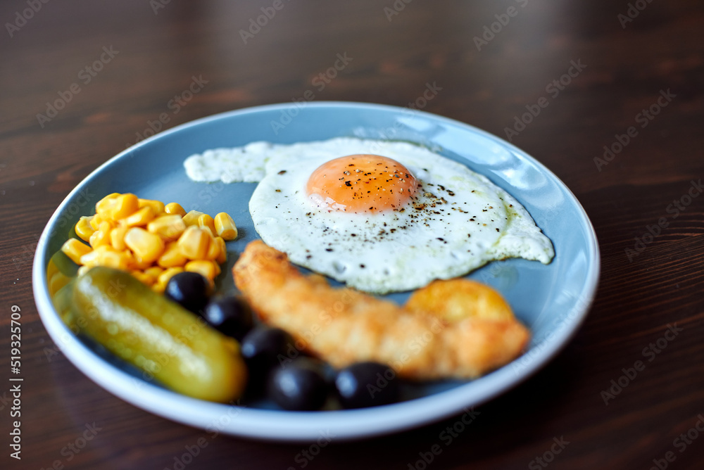 Beautiful breakfast in a blue plate on a wood table. Fried eggs with ...