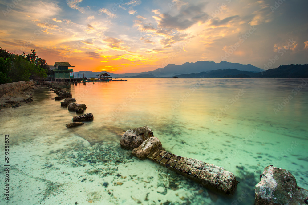 stunning sunset on the beach Tanjung Putus Lampung. building on a clear ...