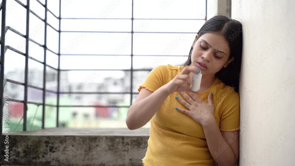 Asthmatic patient catching inhaler having an asthma attack. Young woman ...