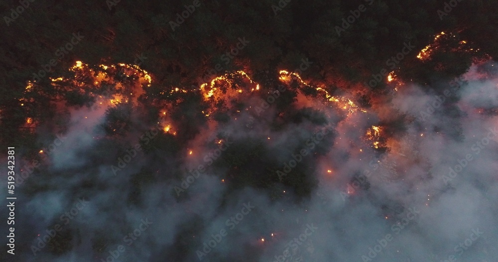Aerial panoramic view of a forest fire at night, heavy smoke causes air ...