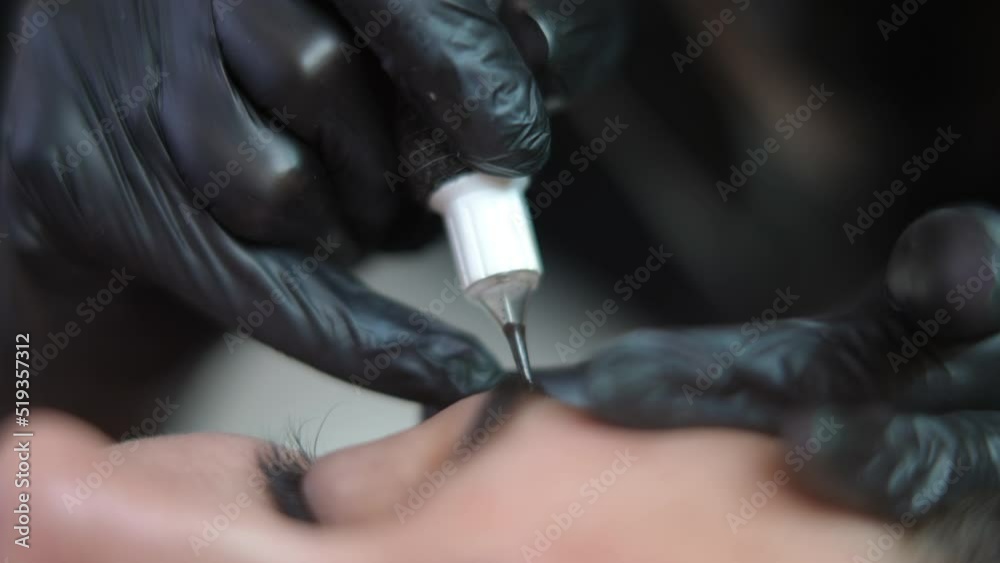 Close-up hand of tattoo master using microblading pen injecting ink in ...