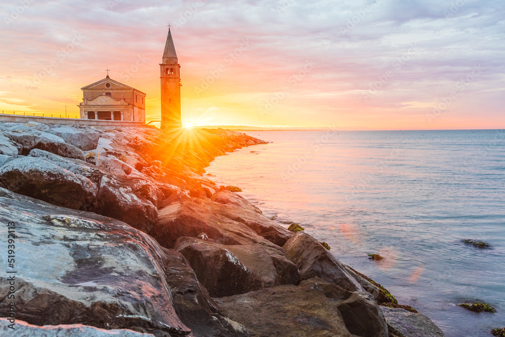The city of Caorle in Italy at sunrise and its landmark on the main ...