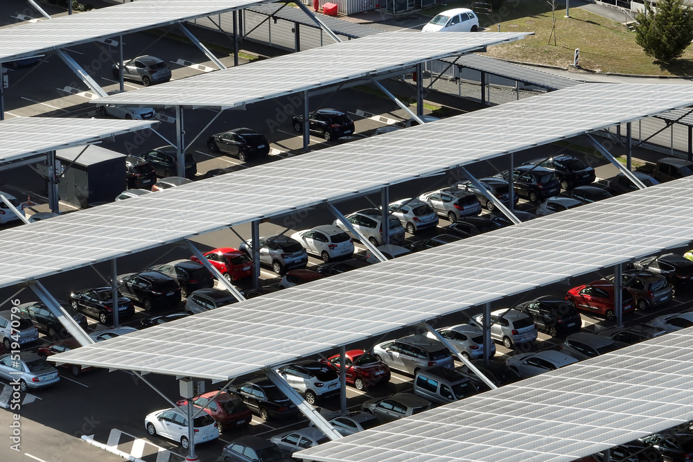 Aerial view of solar panels installed as shade roof over parking lot with parked cars for ...