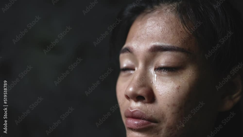 Slow motion, Close-up of a woman crying, tears streaming down her face ...