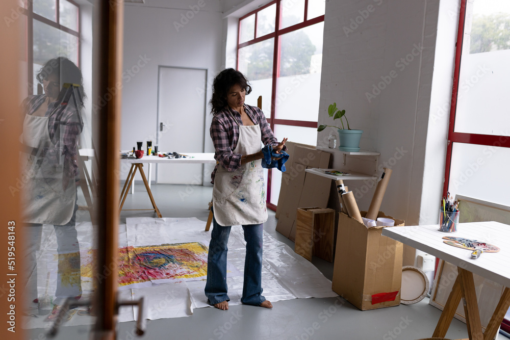 Image of biracial female artist in apron cleaning hands in studio Stock ...