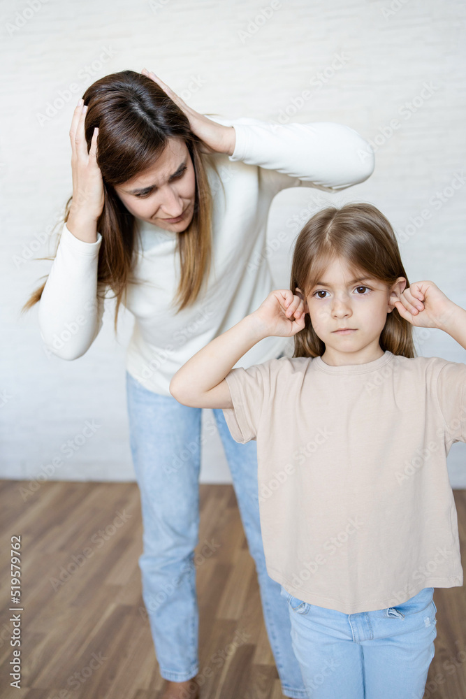 Little girl is ignoring mom, close her ears with arms. Complicated ...