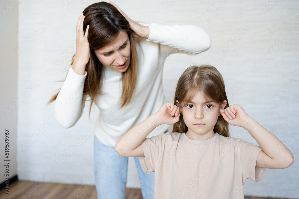 Little girl is ignoring mom, close her ears with arms. Complicated ...