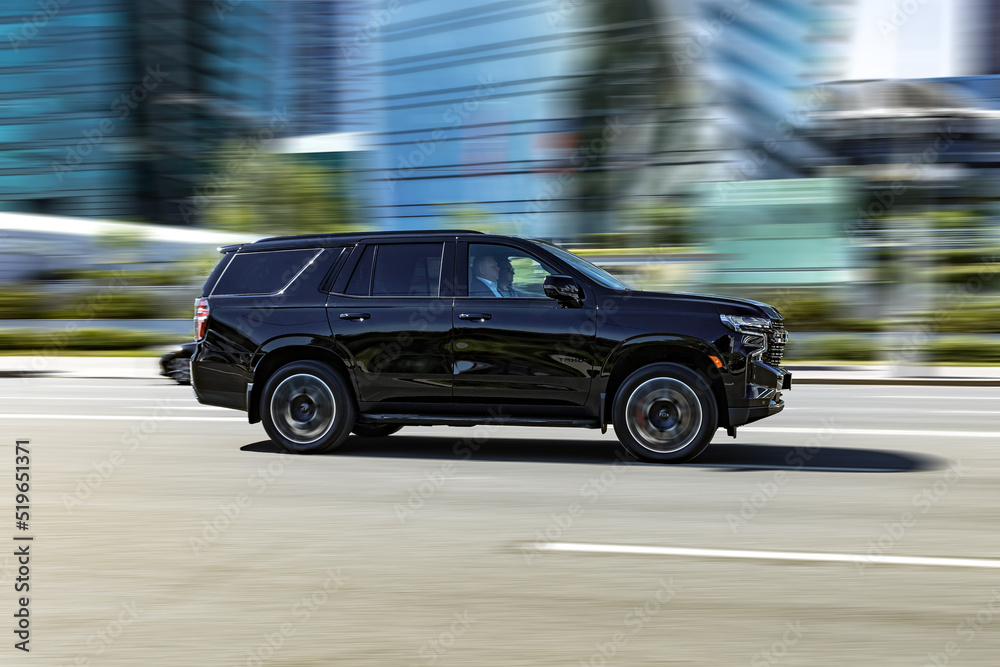 Chevrolet Tahoe car moving in the street. Man is driving fast SUV car ...
