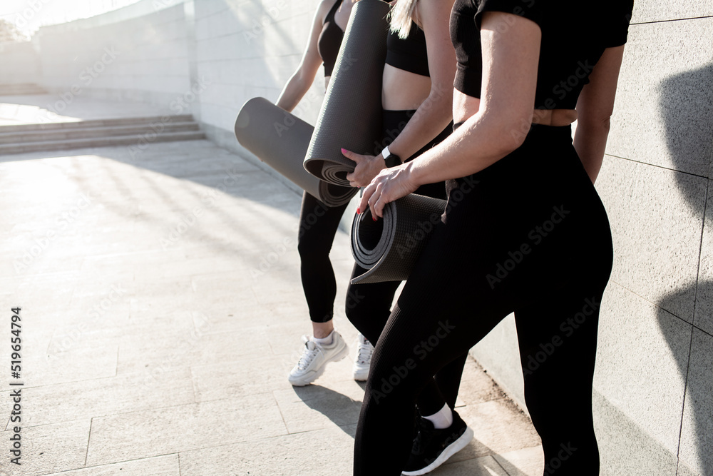 Group of slender girls train on the street against the background of a ...