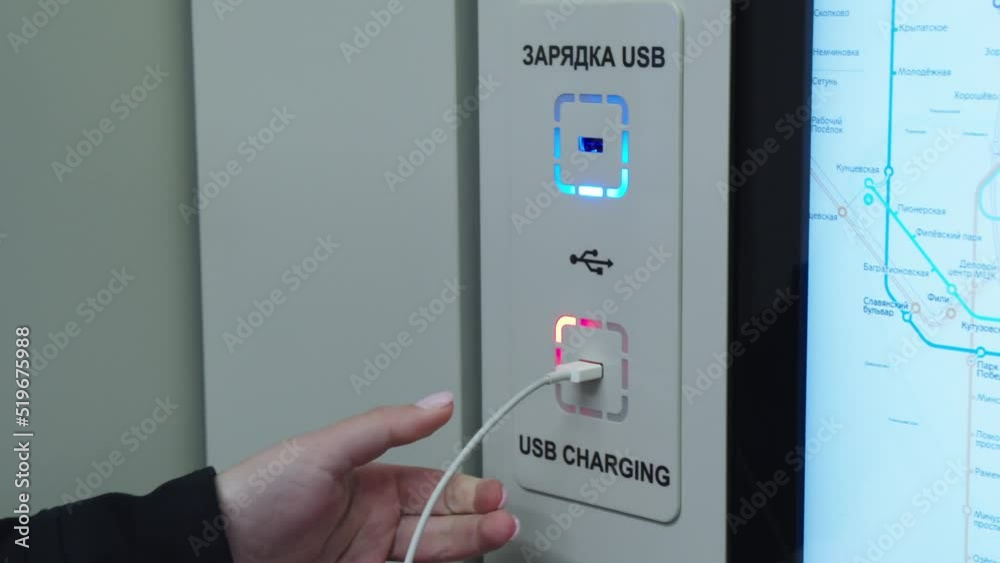 Female hand is plugging the usb cable to the free charging port with ...