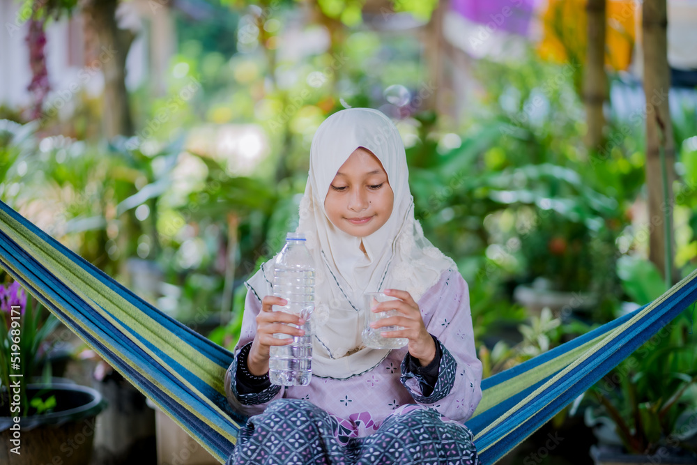 Islamic girl pouring water into a glass Stock Photo | Adobe Stock