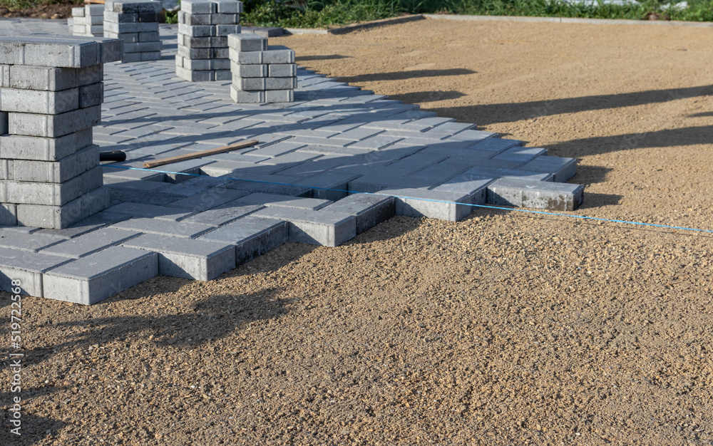Laying paving stones on a garden path. Laying gray concrete paving ...
