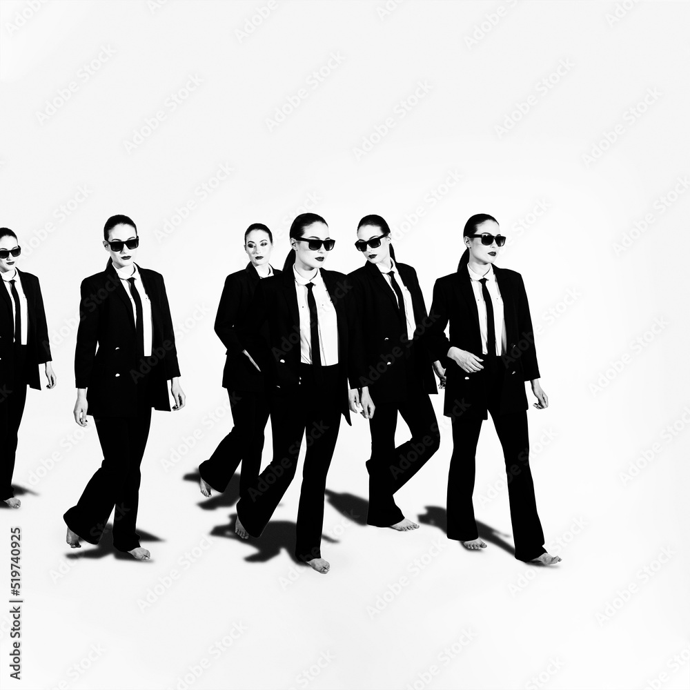 Group of same women in black classic suits, black tie, white shirt and ...