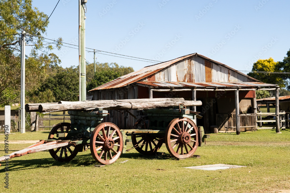 Old logging wagon in front of a country shed made of corrugated iron ...