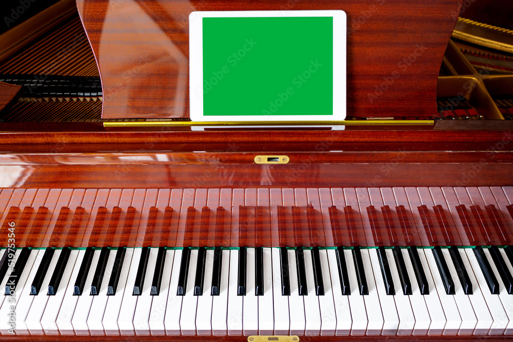 Foto de On the piano there is a tablet with an empty field, chroma key ...