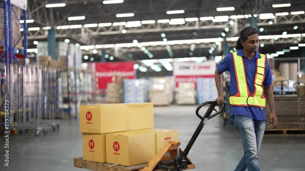 In the warehouse storage area superviorand staff pulling manual pallet ...