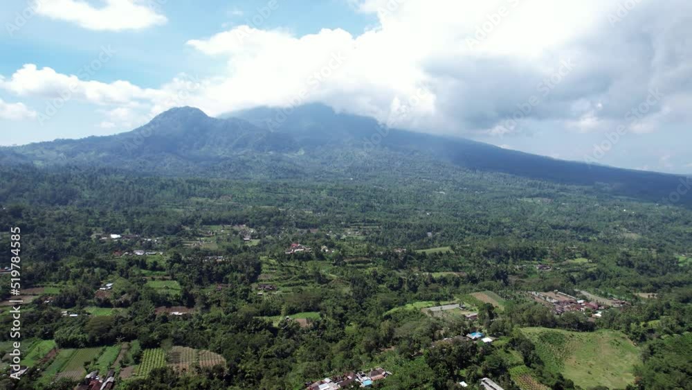 Agung mountain seen ahead, top is in white clouds. Green volcanic ...