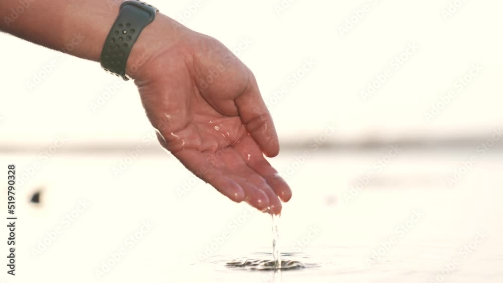 Man hand is touching water. Clean ocean. Fingers touch water in lake ...