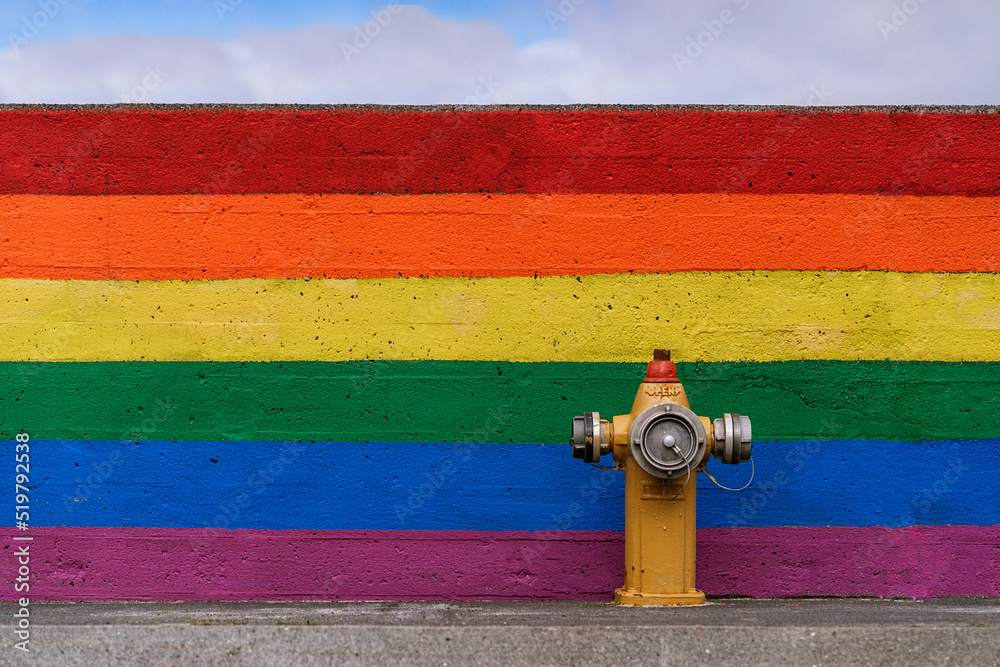 Fire hydrant on asphalt road near wall with rainbow flag Stock Photo ...