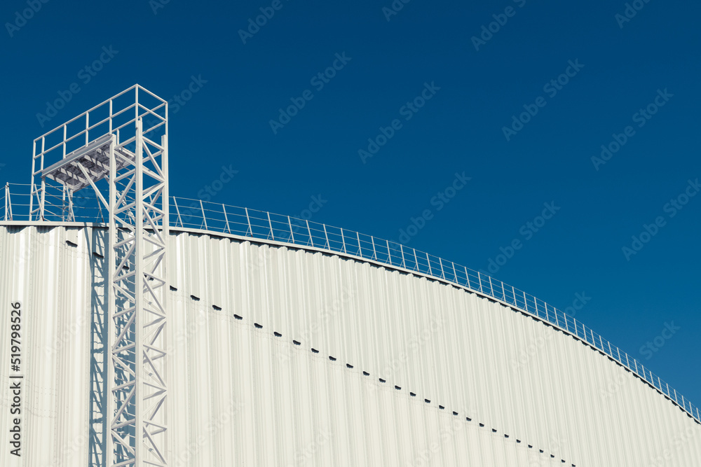 A modern hangar with a staircase to the roof on a blue sky background ...